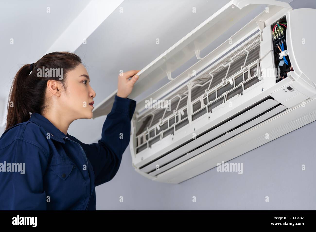 female technician service checking and repairing the air conditioner ...