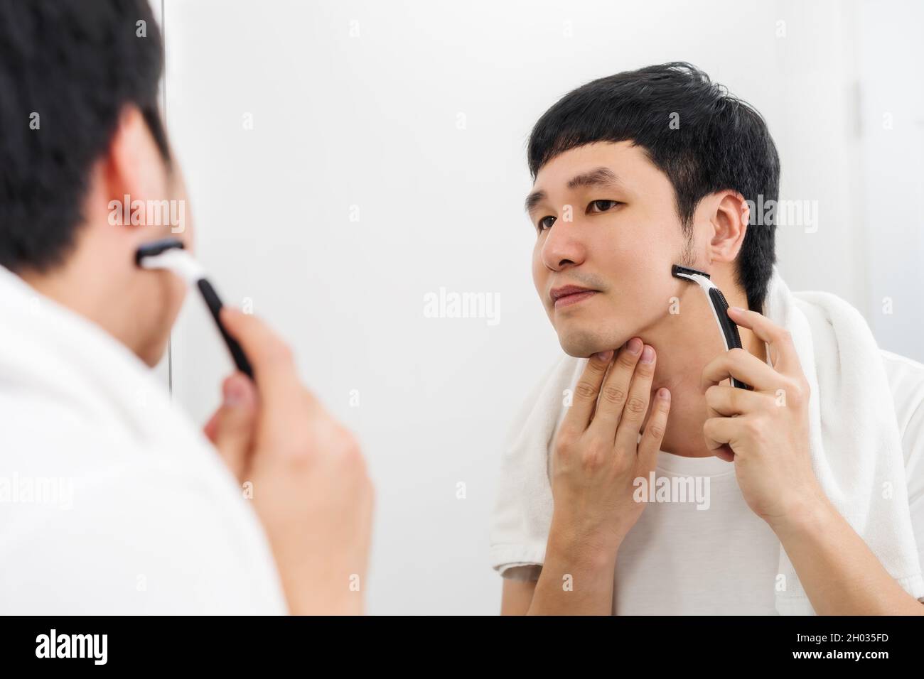 man using razor to shaving his face without foam, dry shave in the ...