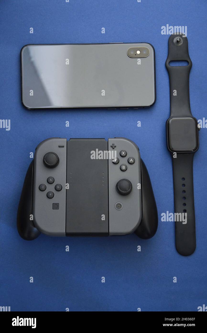 Photo of a gaming controller, mobile phone and smart watch on blue ...