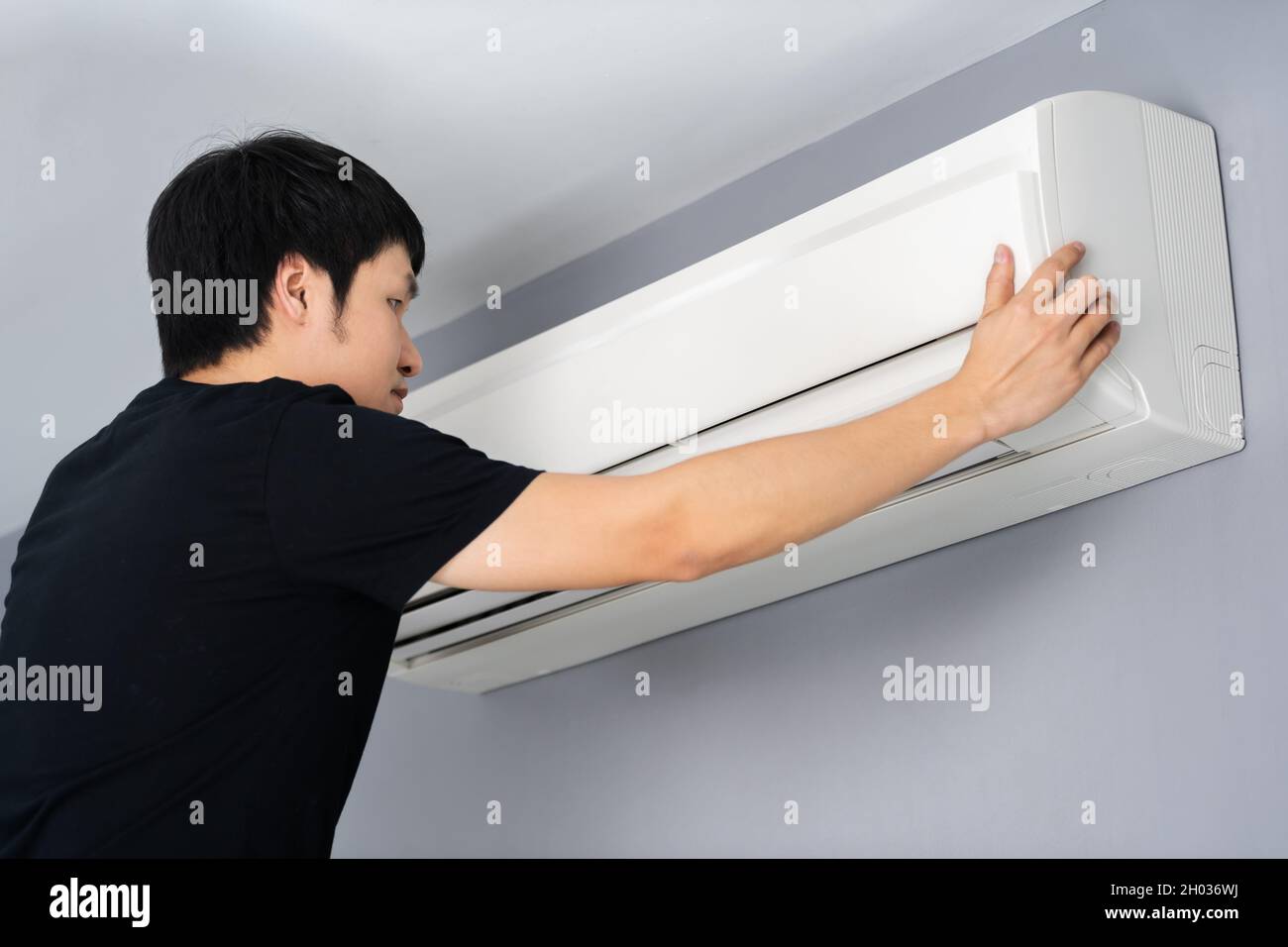young man with the air conditioner indoor at home Stock Photo - Alamy