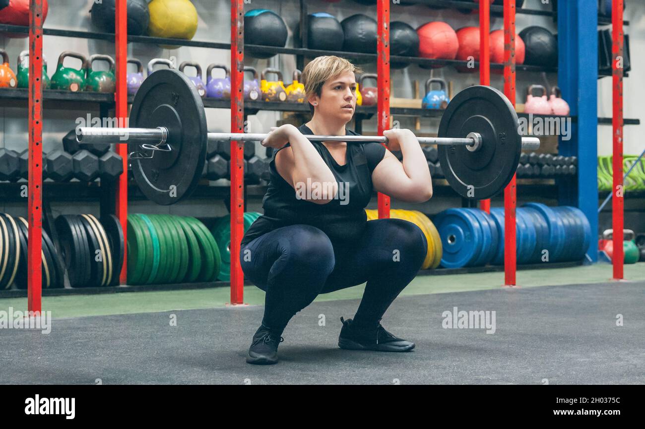 Woman practicing weightlifting in the gym Stock Photo - Alamy