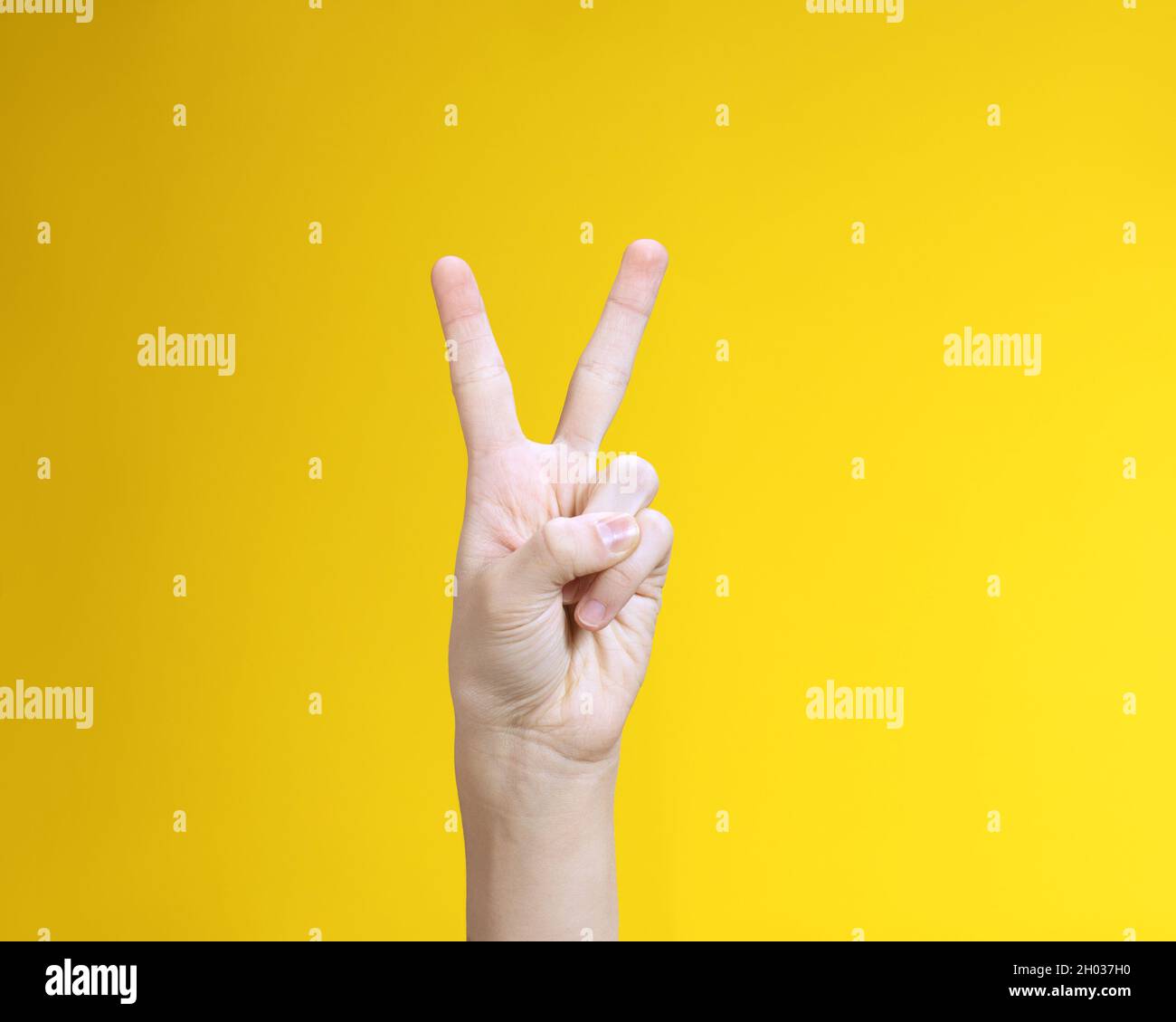 Human arm with victory gesture on yellow background. symbol of triumph ...