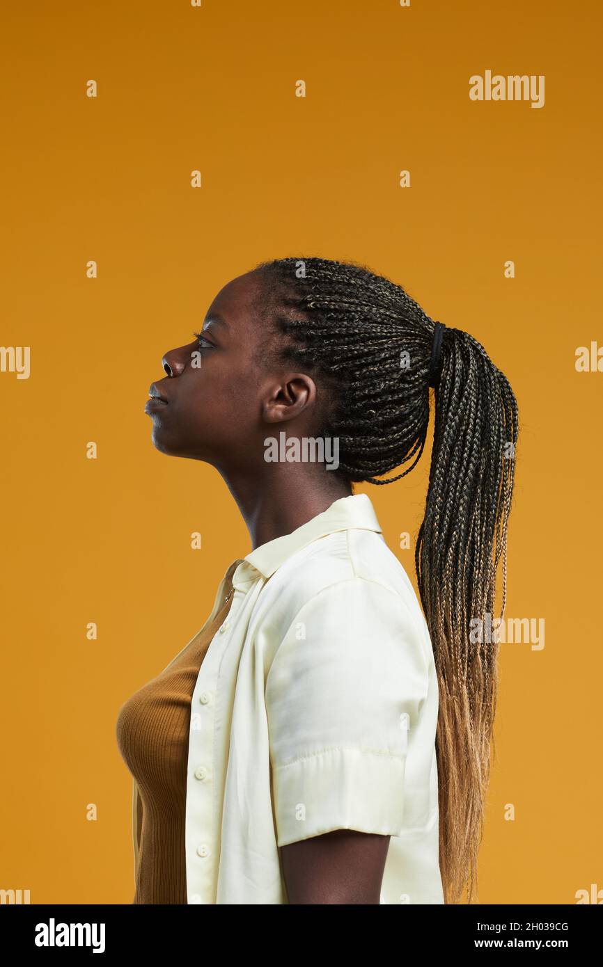 Minimal side view portrait of young African-American woman standing ...