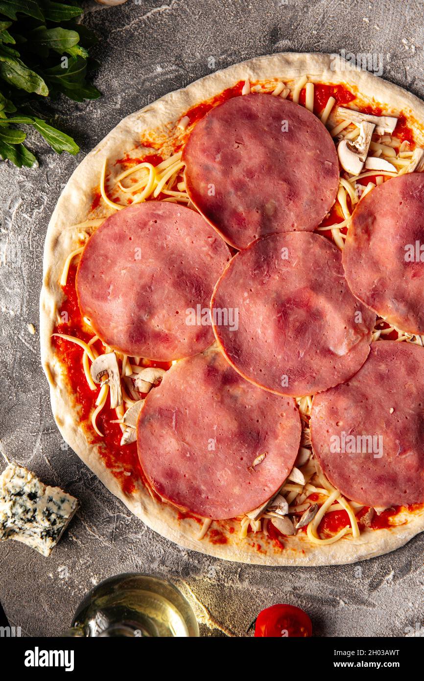 Prepared dough base for pizza with toppings Stock Photo - Alamy
