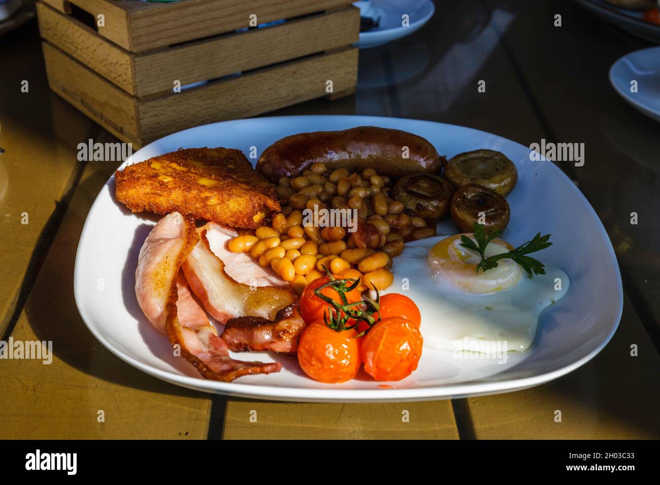 traditional full English breakfast with fried eggs, sausages, beans ...