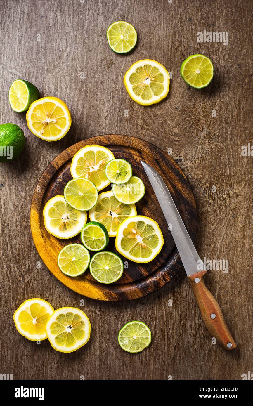 sliced on lemon, lime slate and wooden counter top background Stock ...