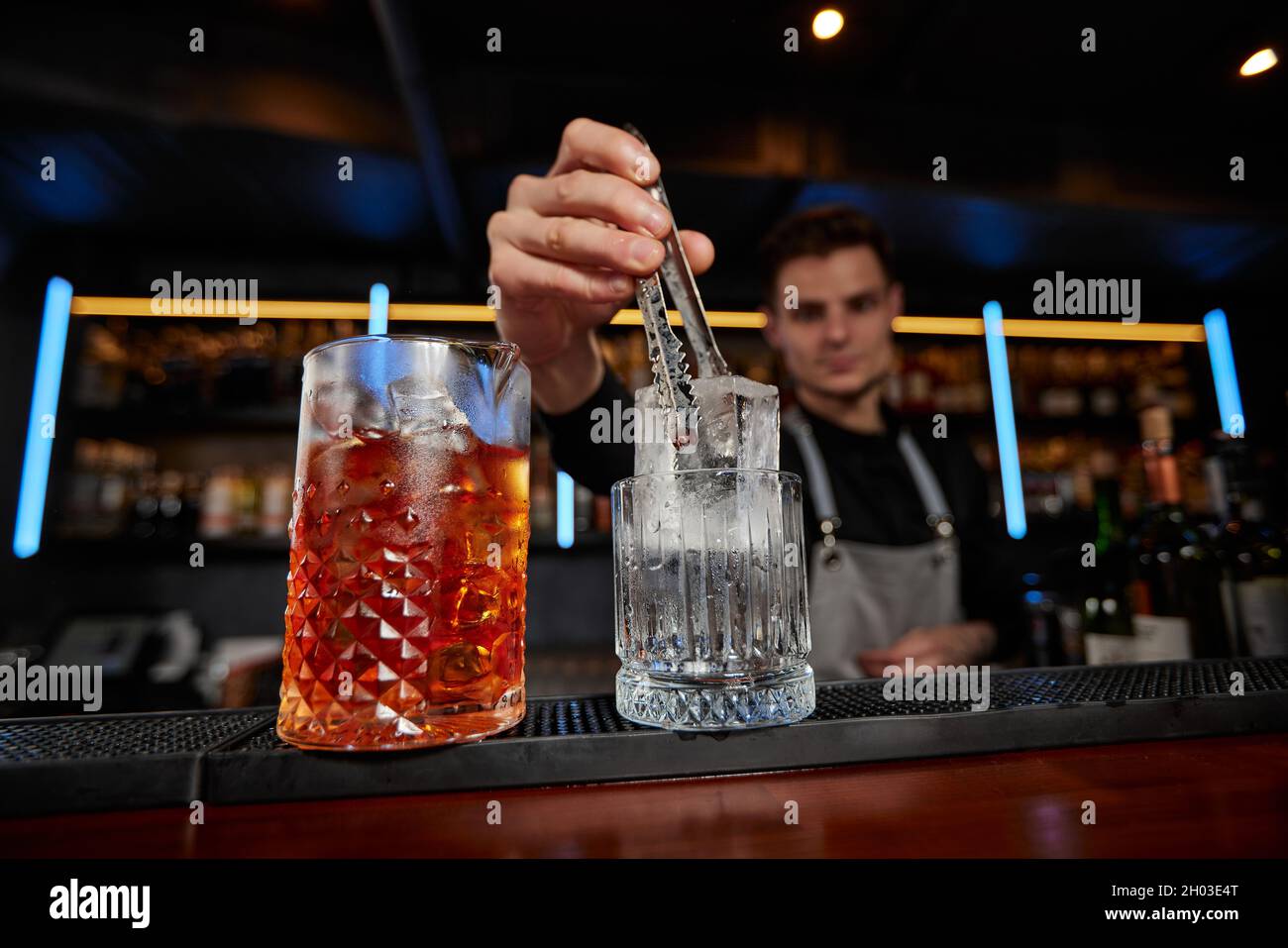 Barman puts the ice cubes into a glass Stock Photo - Alamy