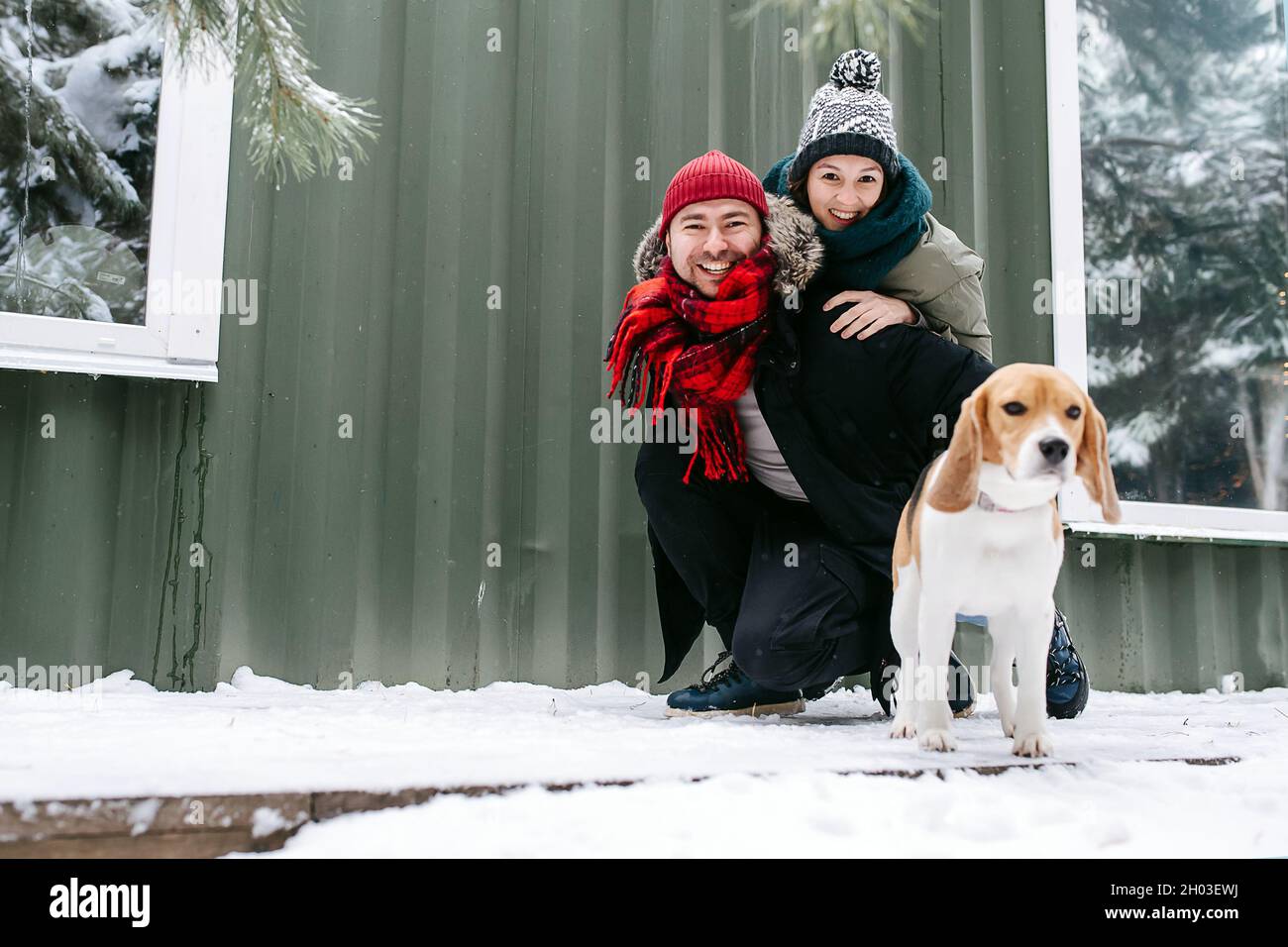 Adorable couple posing for a photo with their beagle outdoors at winter ...