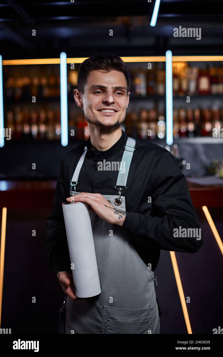 Handsome barman in apron standing at the bar counter Stock Photo - Alamy