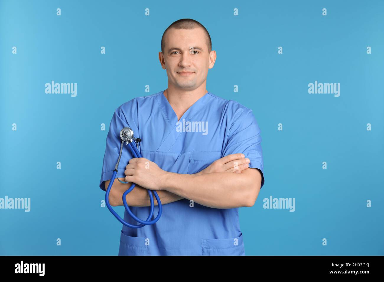 Portrait of medical assistant with stethoscope on color background ...