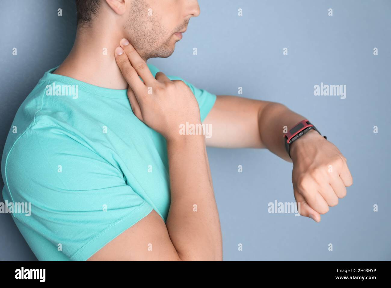 Young man checking pulse on color background, closeup Stock Photo - Alamy