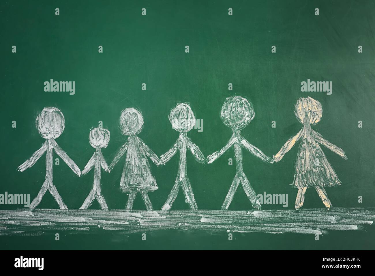 Drawing of people holding hands together on chalkboard. Unity concept ...