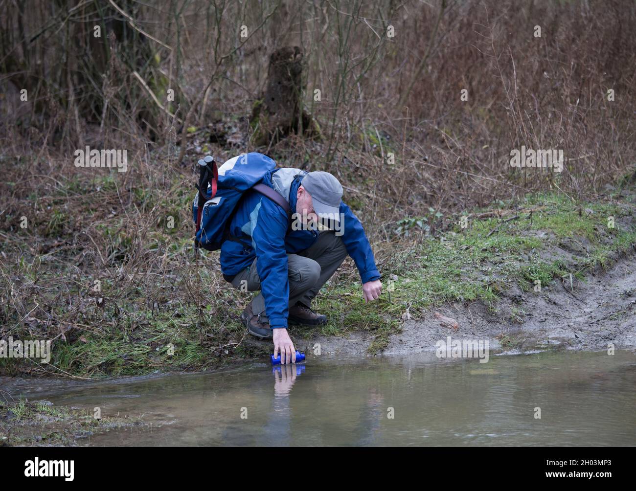 Man picking water from river for drinking in forest in winter Stock ...