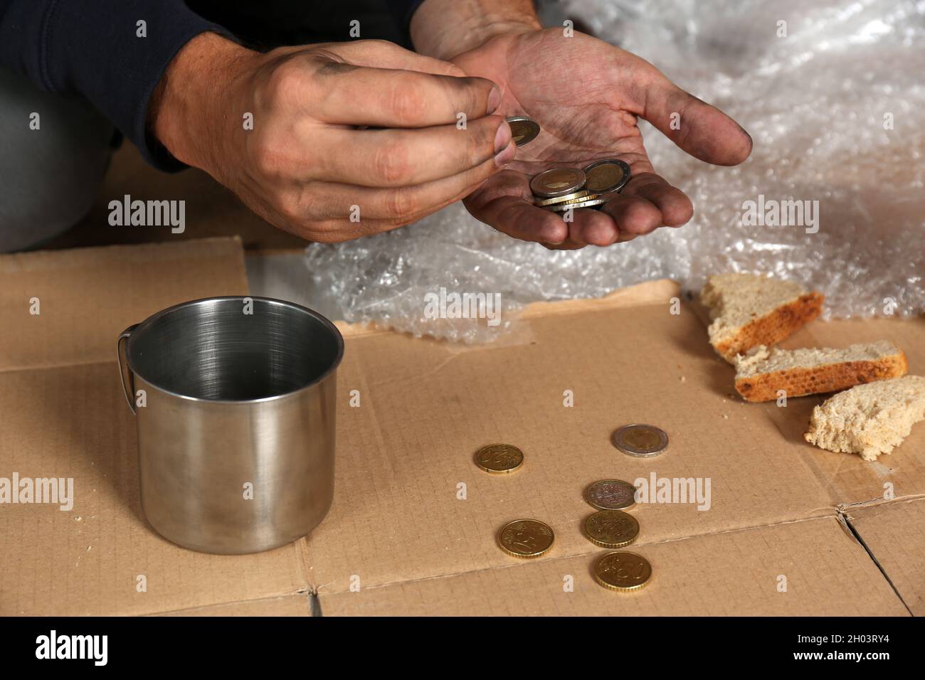 Poor man counting coins over cardboard on floor, closeup Stock Photo ...