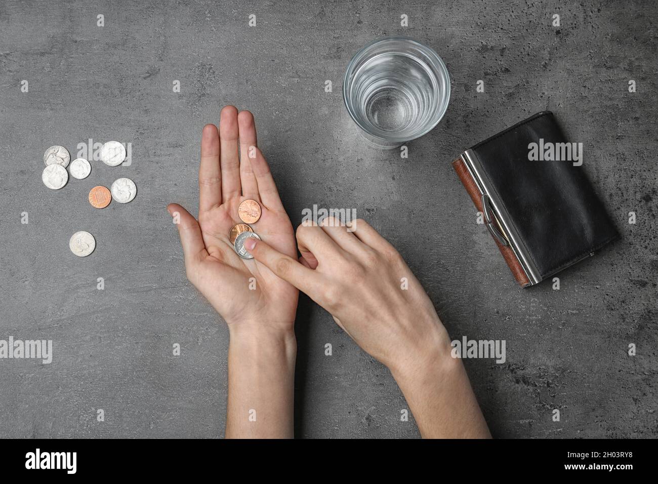 Poor woman counting coins on grey background, top view Stock Photo - Alamy