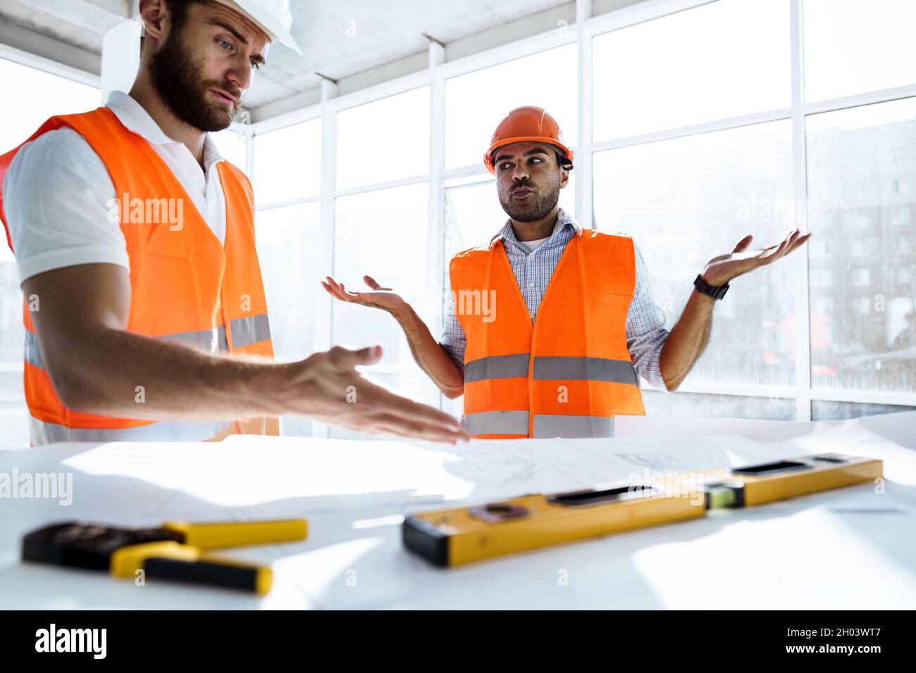Two engineers man looking at project plan on the table in construction ...