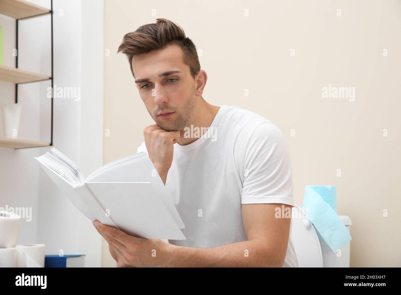 Man on toilet reading book hi-res stock photography and images - Alamy