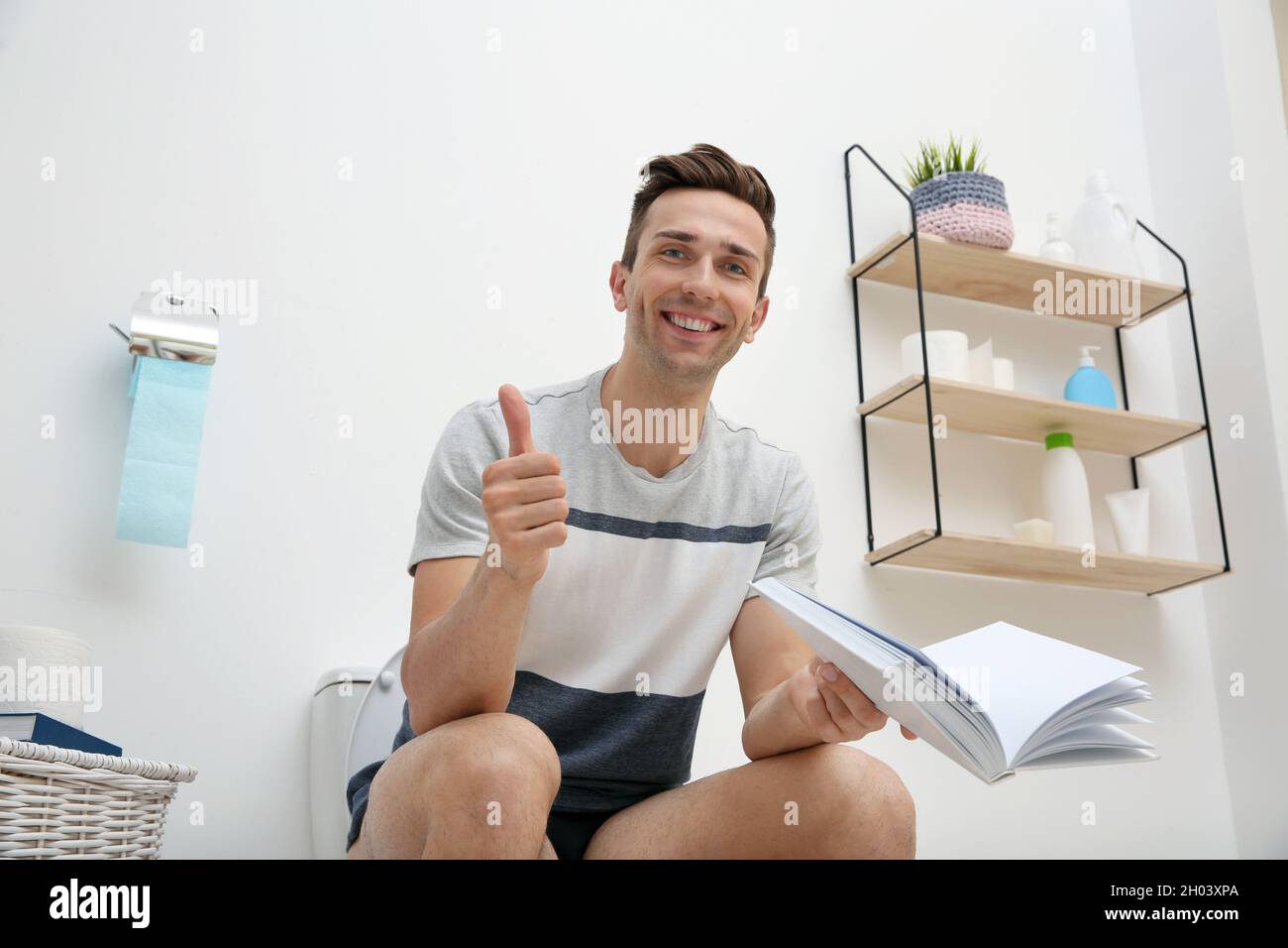 Man on toilet reading book hi-res stock photography and images - Alamy
