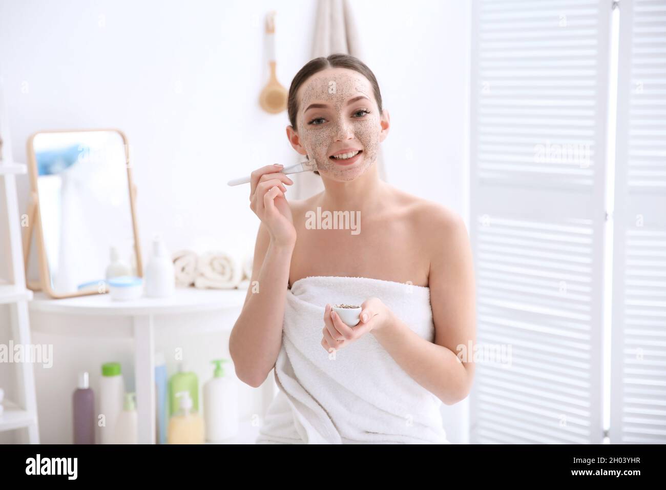 Woman applying scrub onto face in bathroom Stock Photo - Alamy