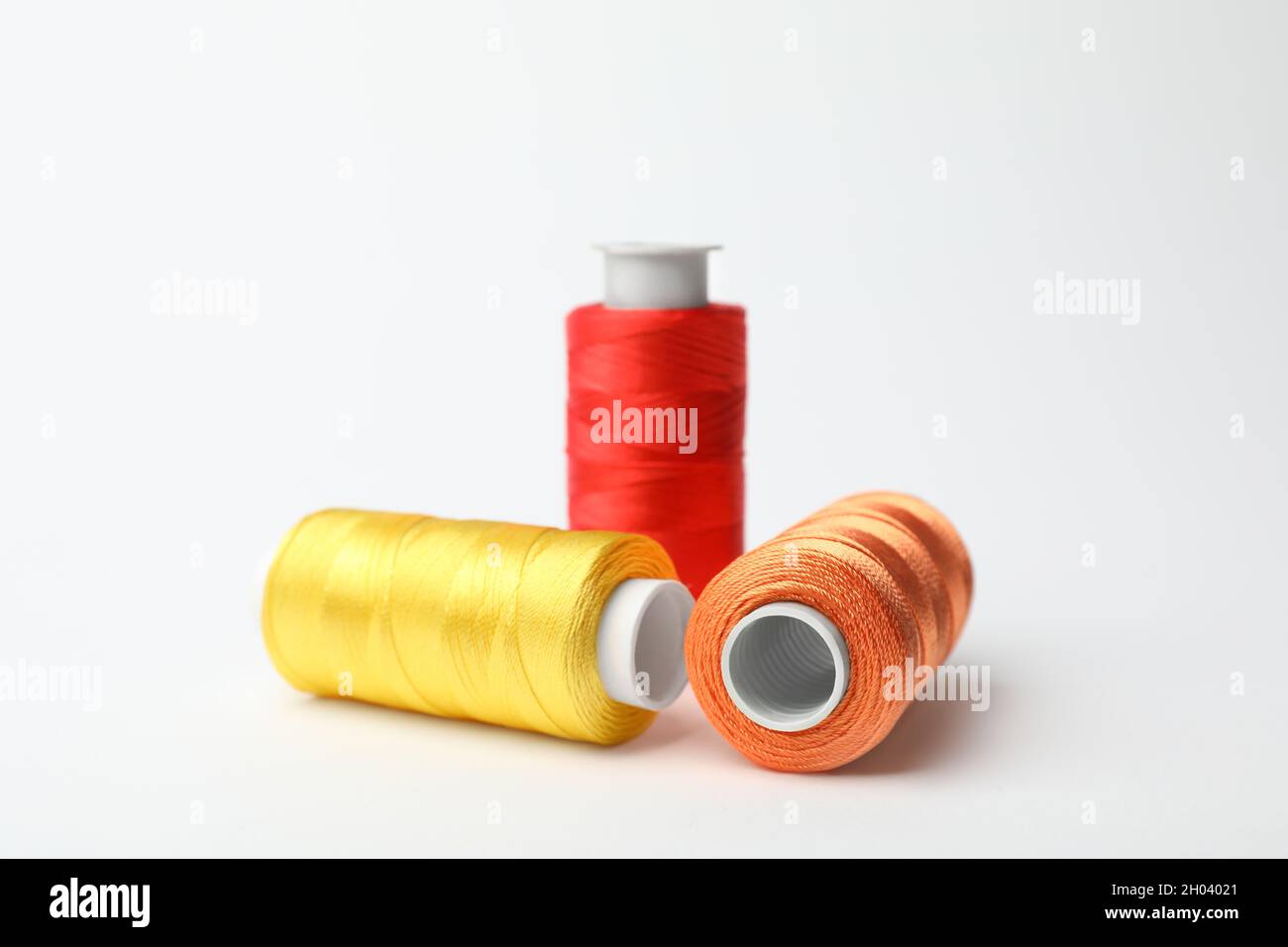 Color sewing threads on white background Stock Photo - Alamy