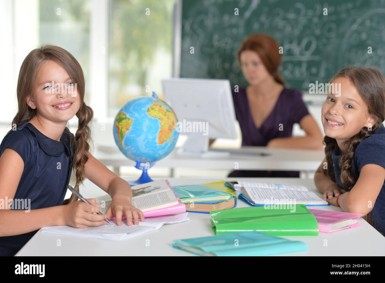 Beautiful girls studying at the desk in class room Stock Photo - Alamy