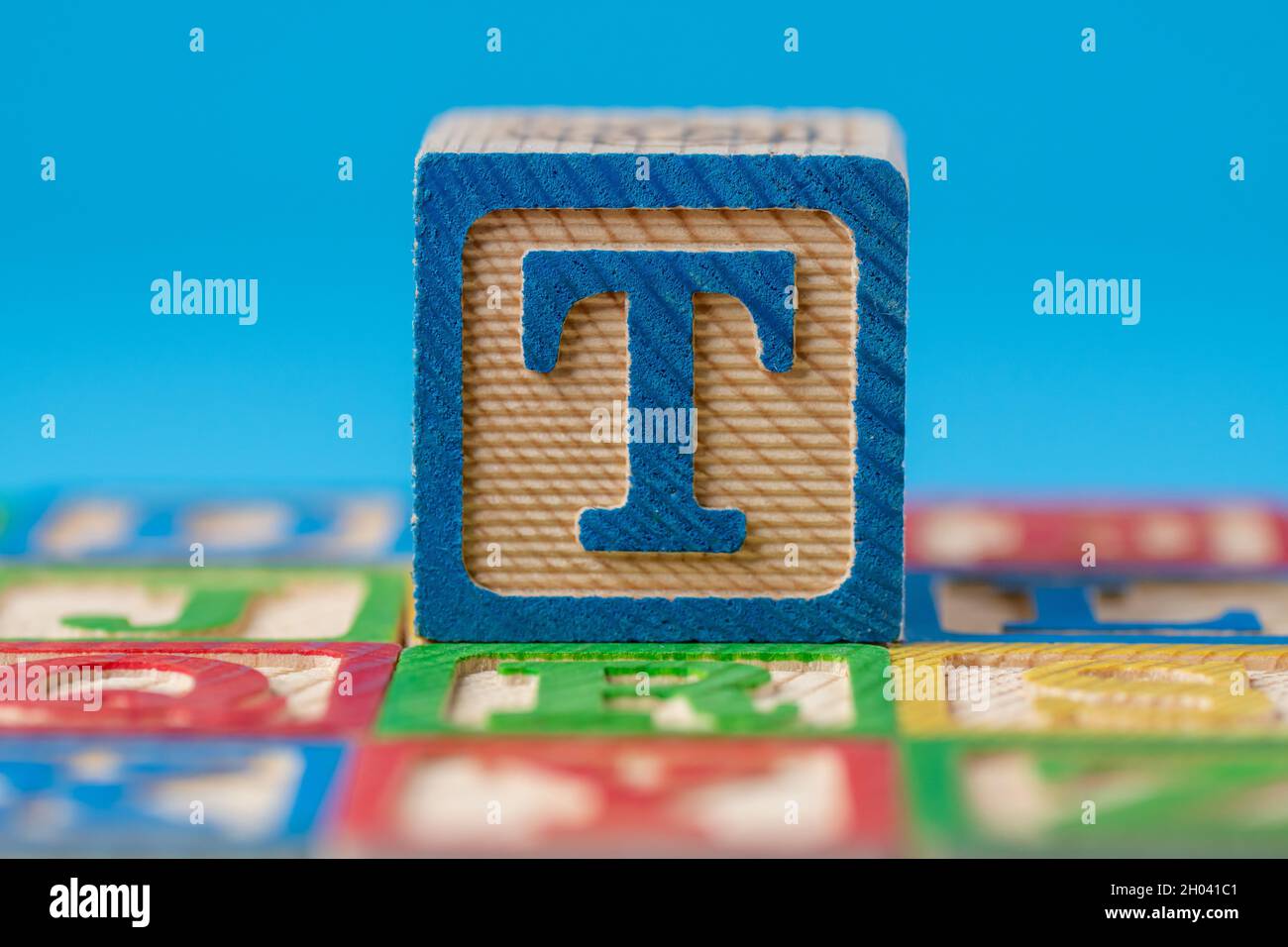 Closeup shot of the wooden toy block with the letter T for learning the ...