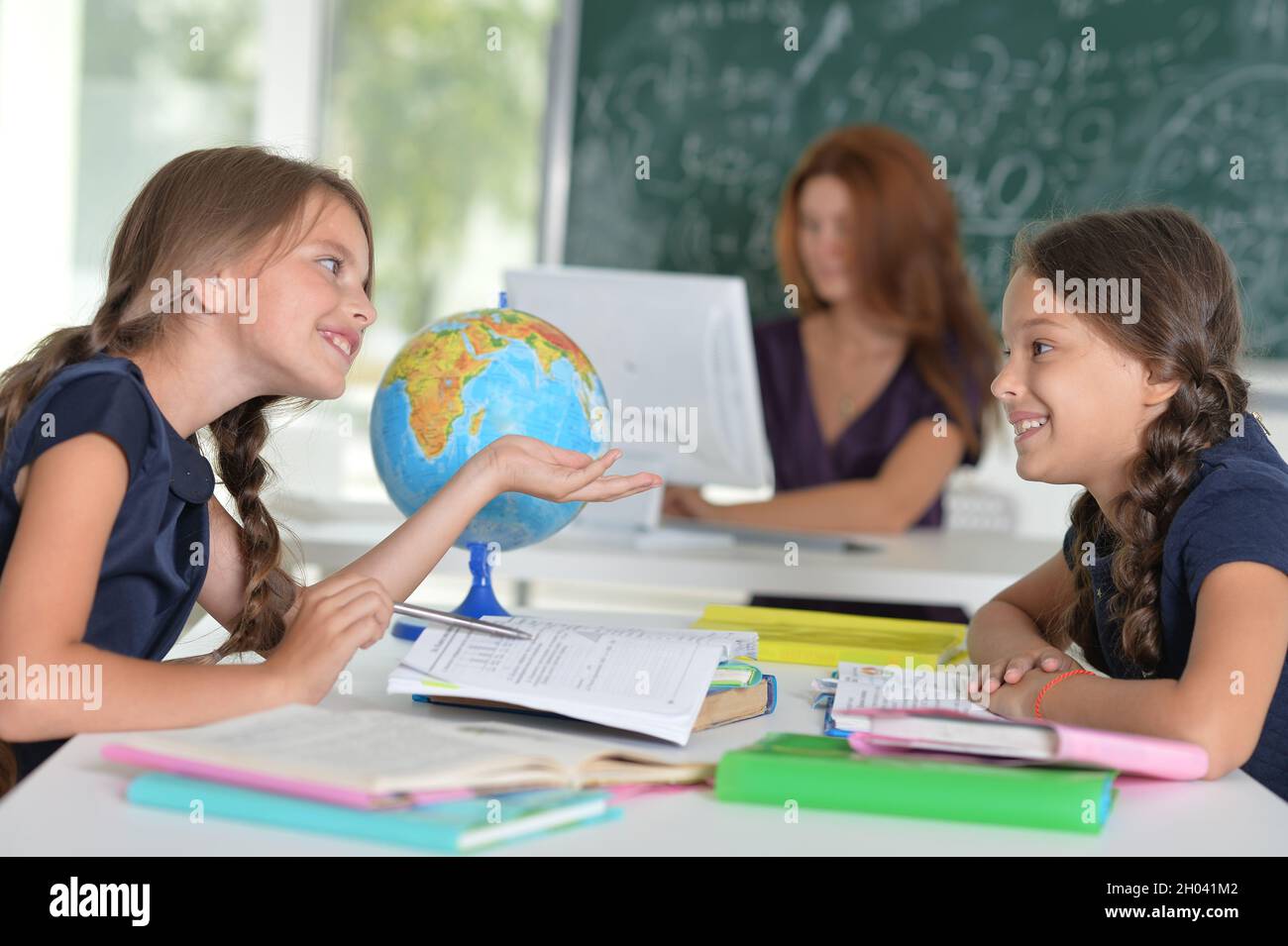 Beautiful girls studying at the desk in class room Stock Photo - Alamy