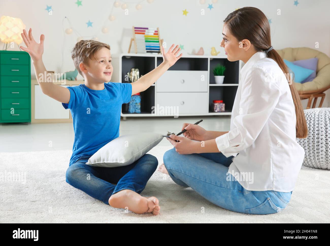 Female psychologist working with cute little boy in office Stock Photo ...