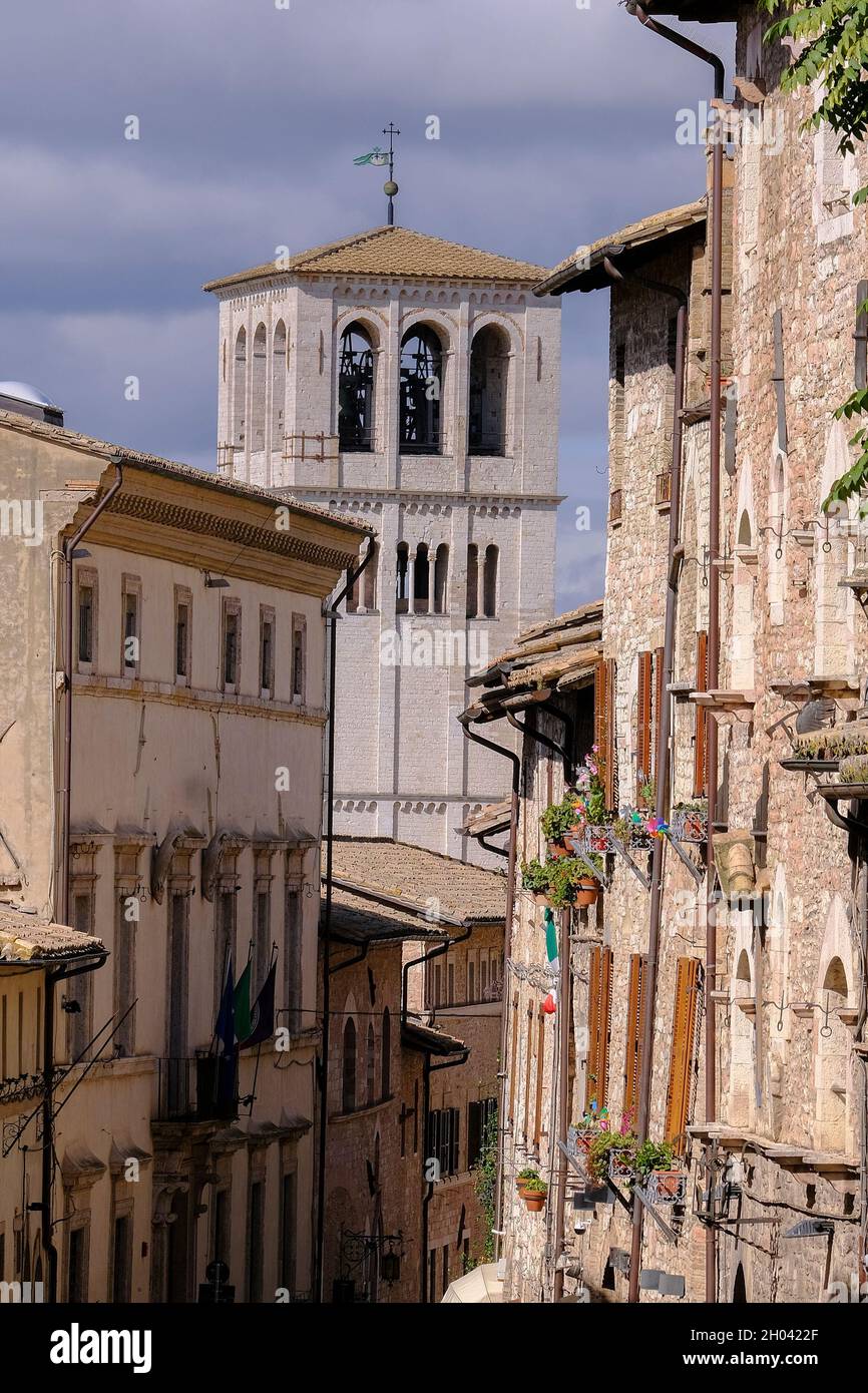 general view of the historic centre of assisi at the end of the street ...