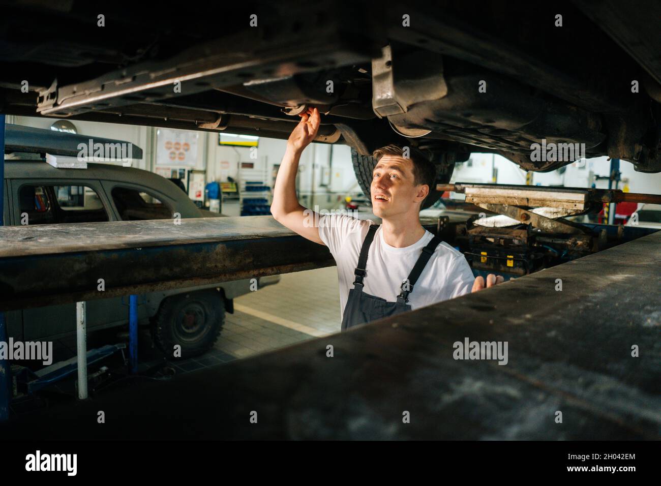 Medium shot portrait of focused handsome professional male car mechanic ...