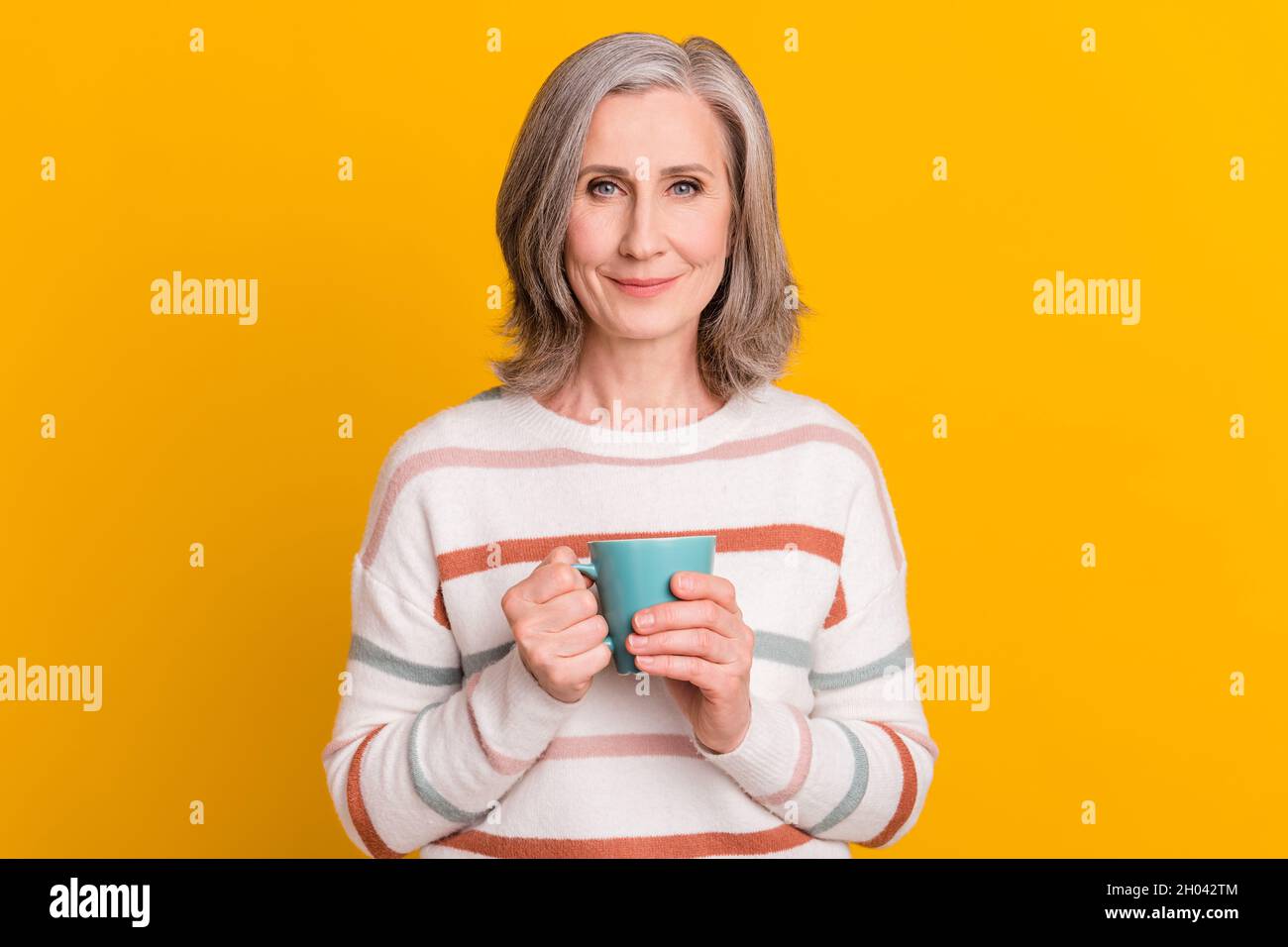 Photo of adorable shiny lady pensioner wear striped pullover drinking ...