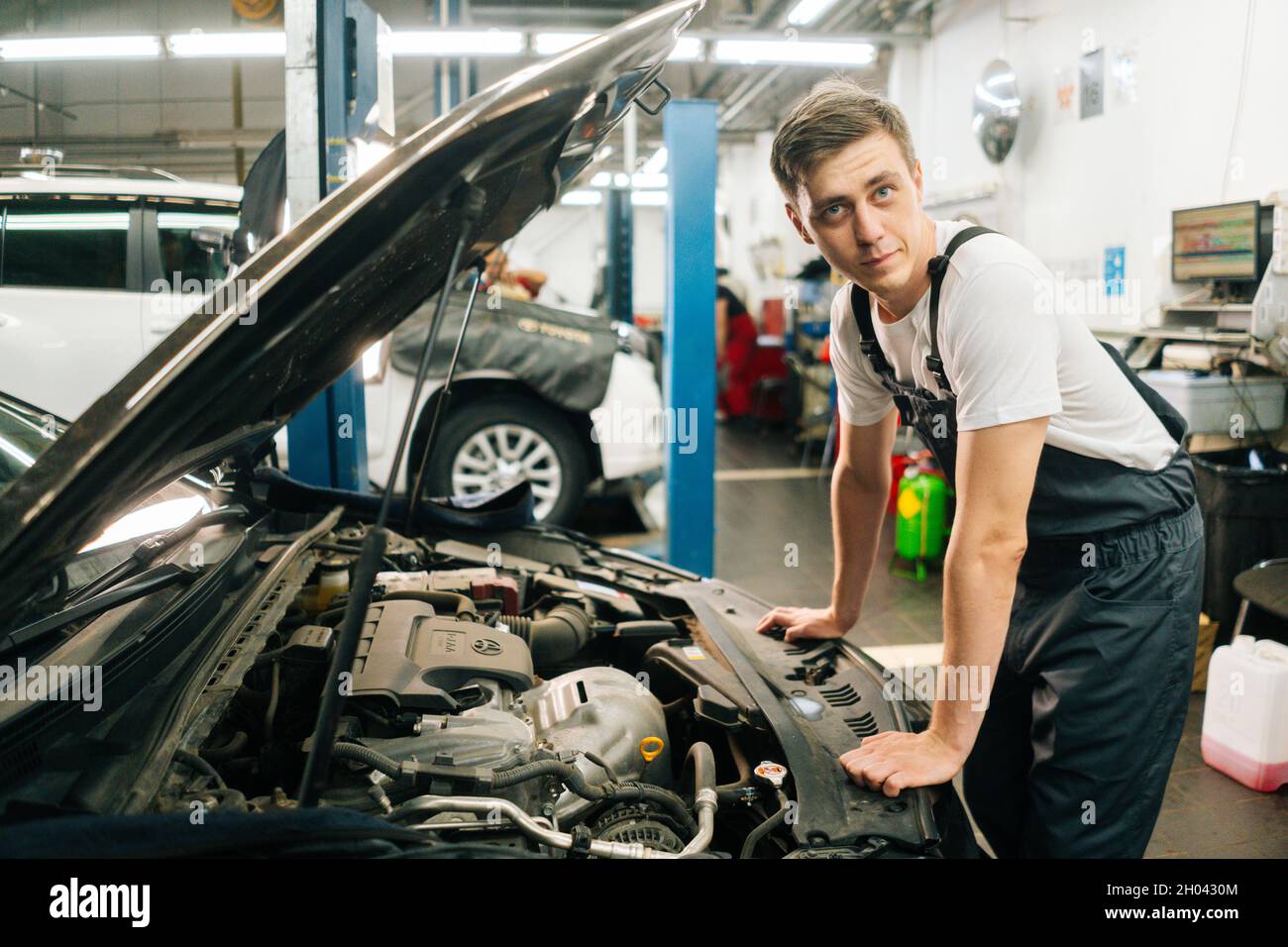 Side view of confident handsome professional male car mechanic in blue ...