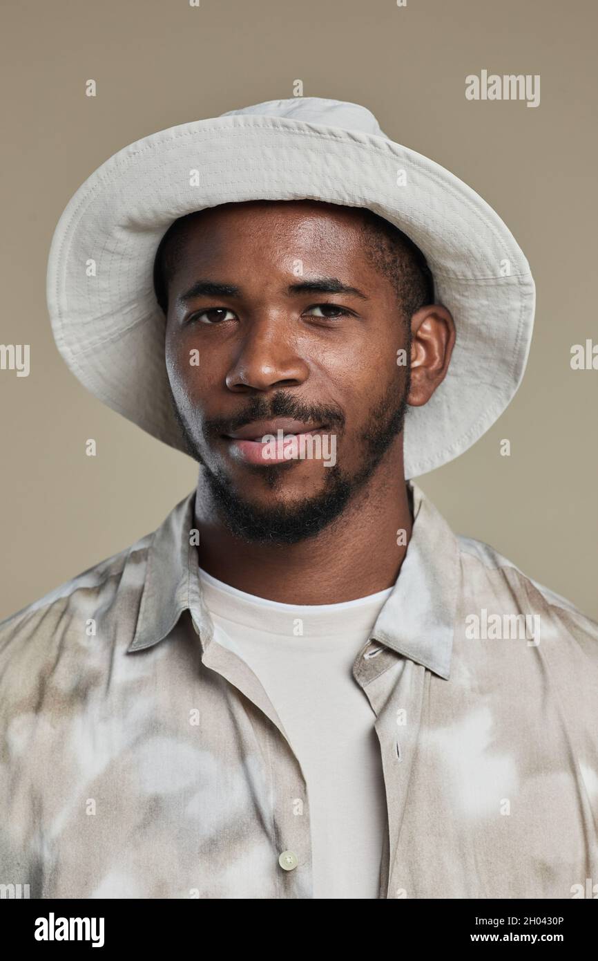 Vertical portrait of African-American man wearing hat and looking at ...