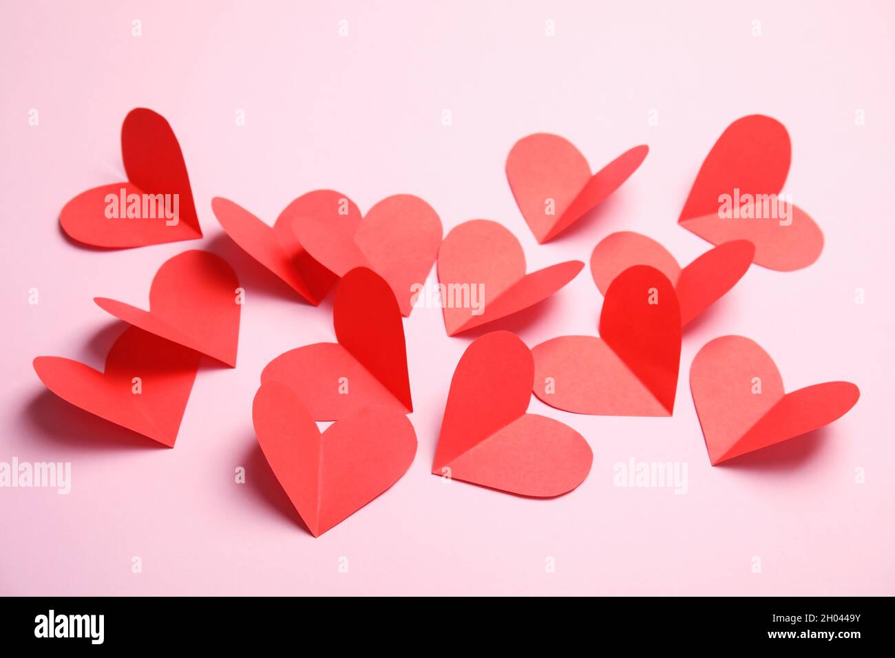 Small paper hearts on color background Stock Photo - Alamy