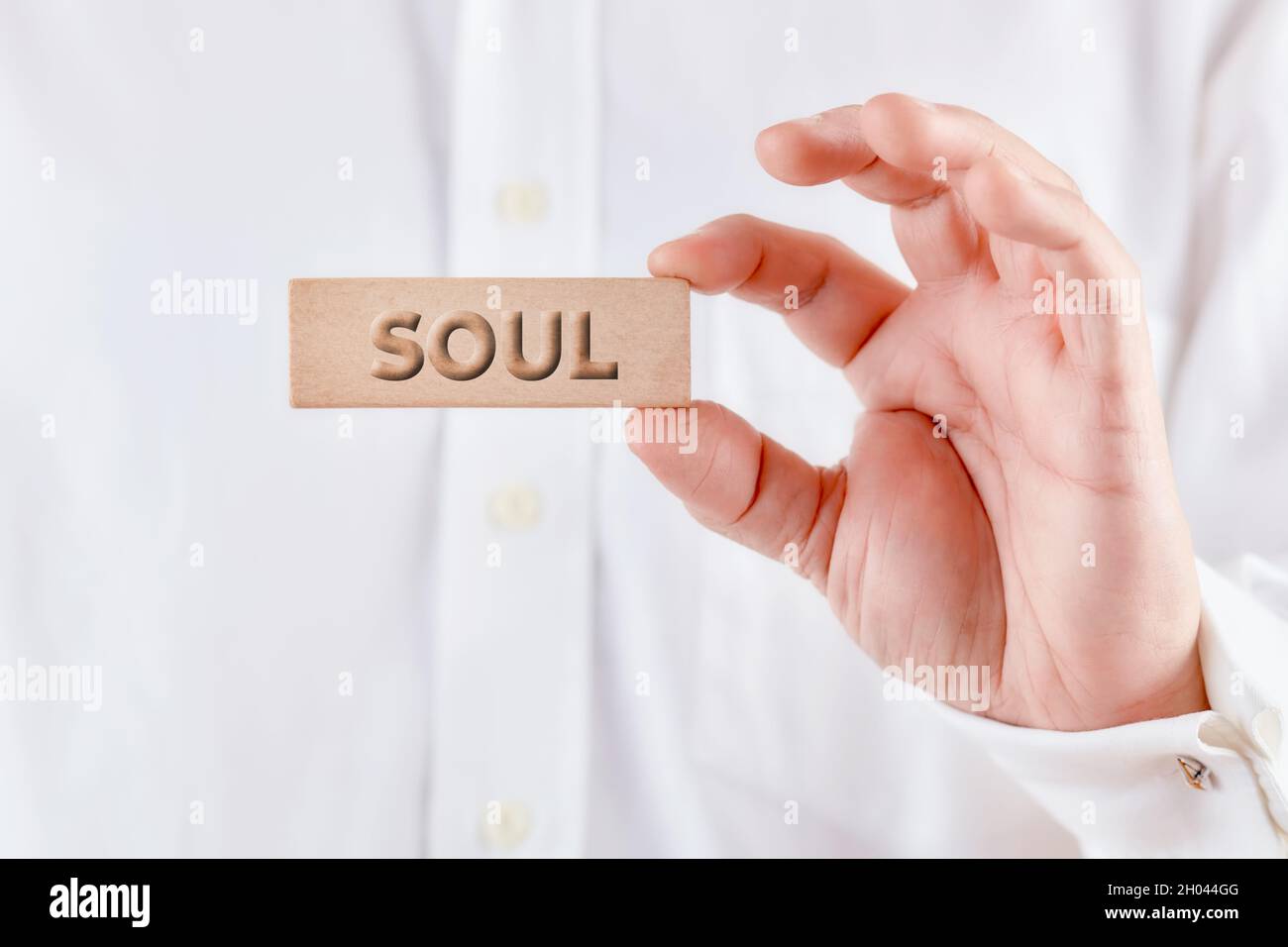 Male hand holds a wooden block with the word soul Stock Photo - Alamy
