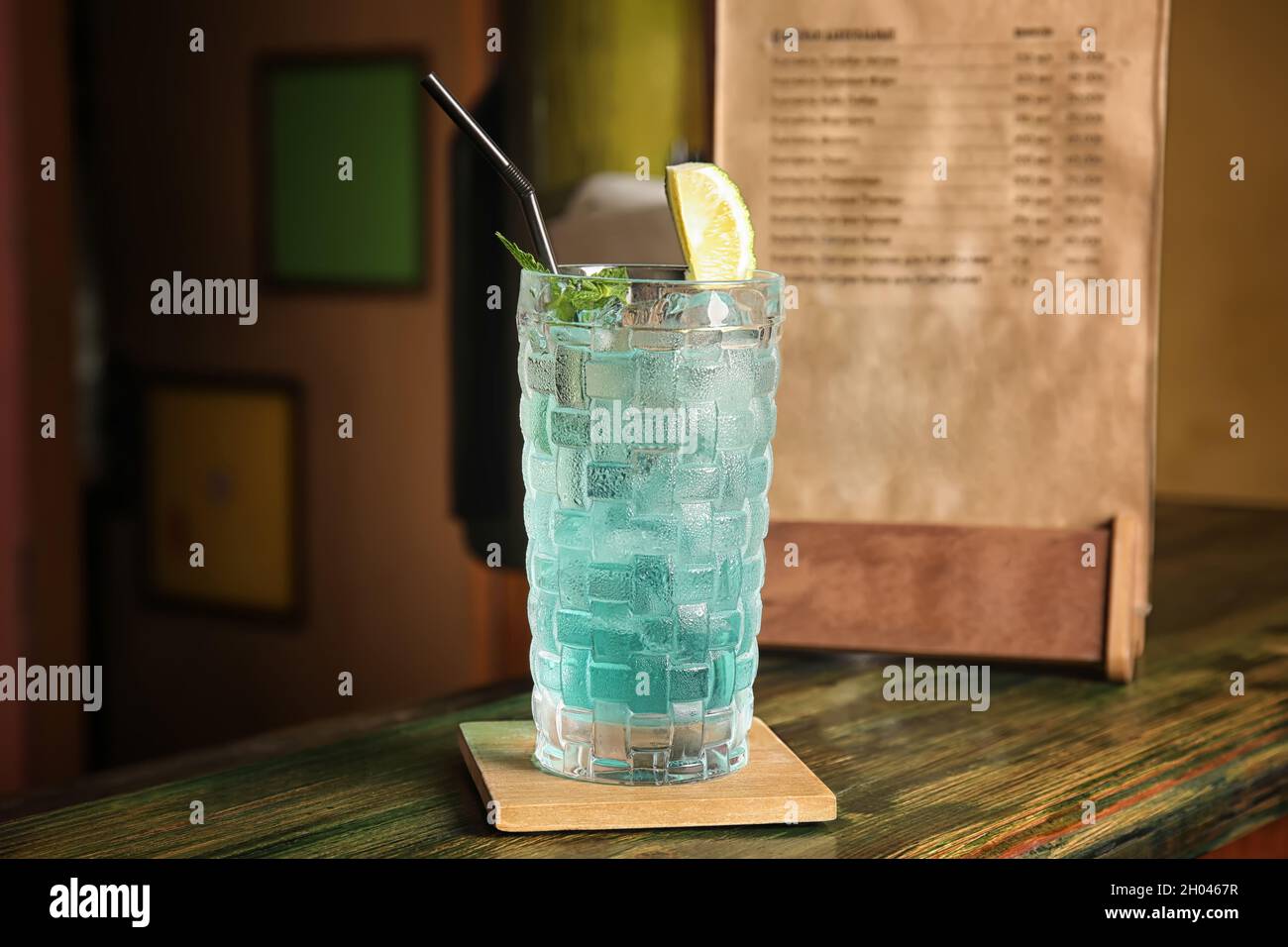 Glass with delicious cocktail and ice cubes on counter in bar Stock ...