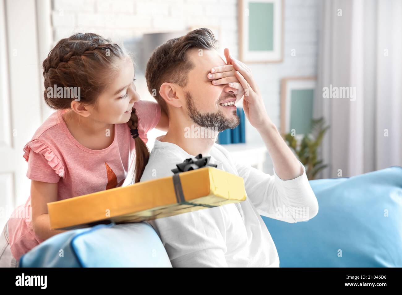 Man receiving gift for Father's Day from his daughter at home Stock ...