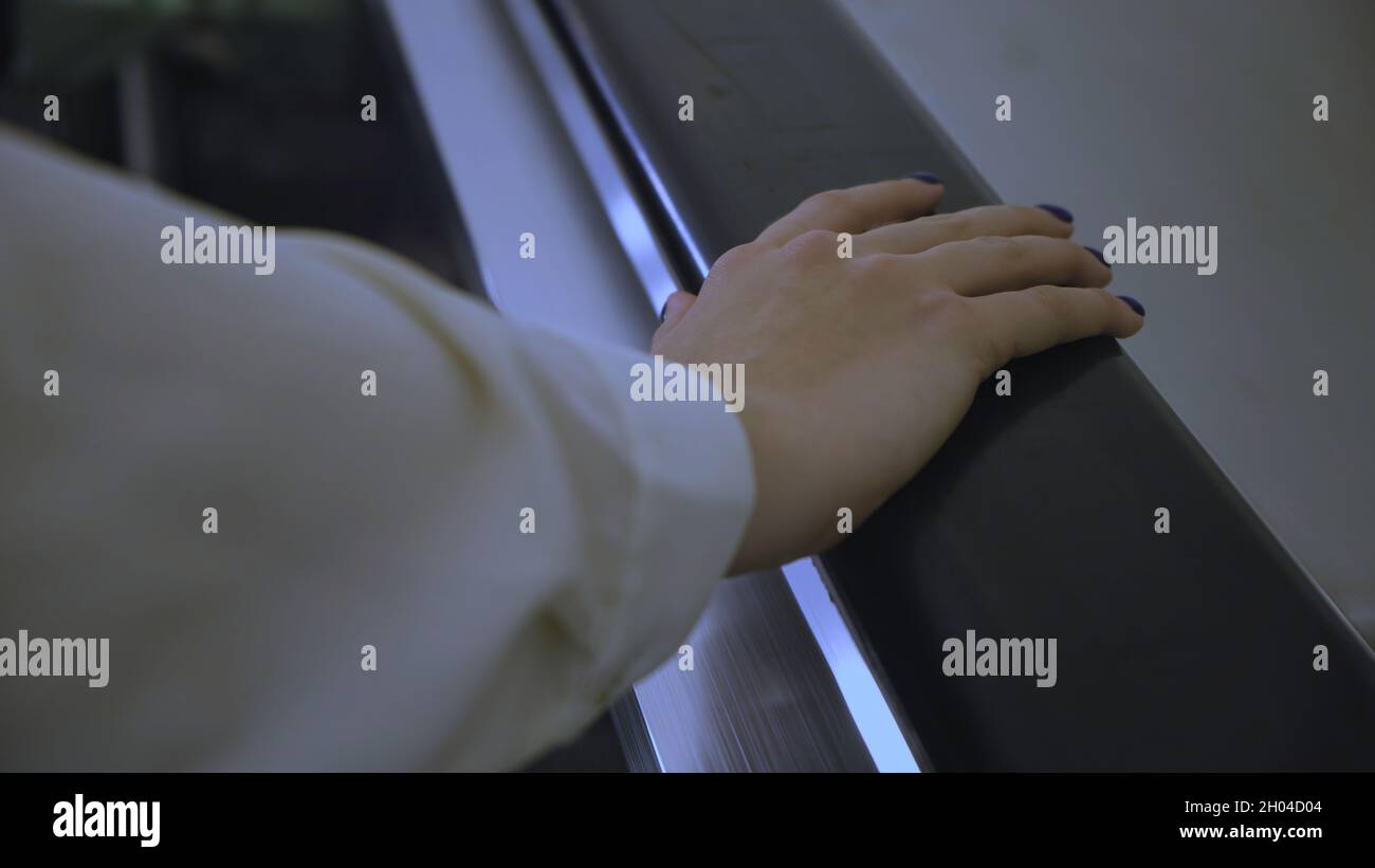 Close up of woman hand holding the handrail of escalator. Young ...