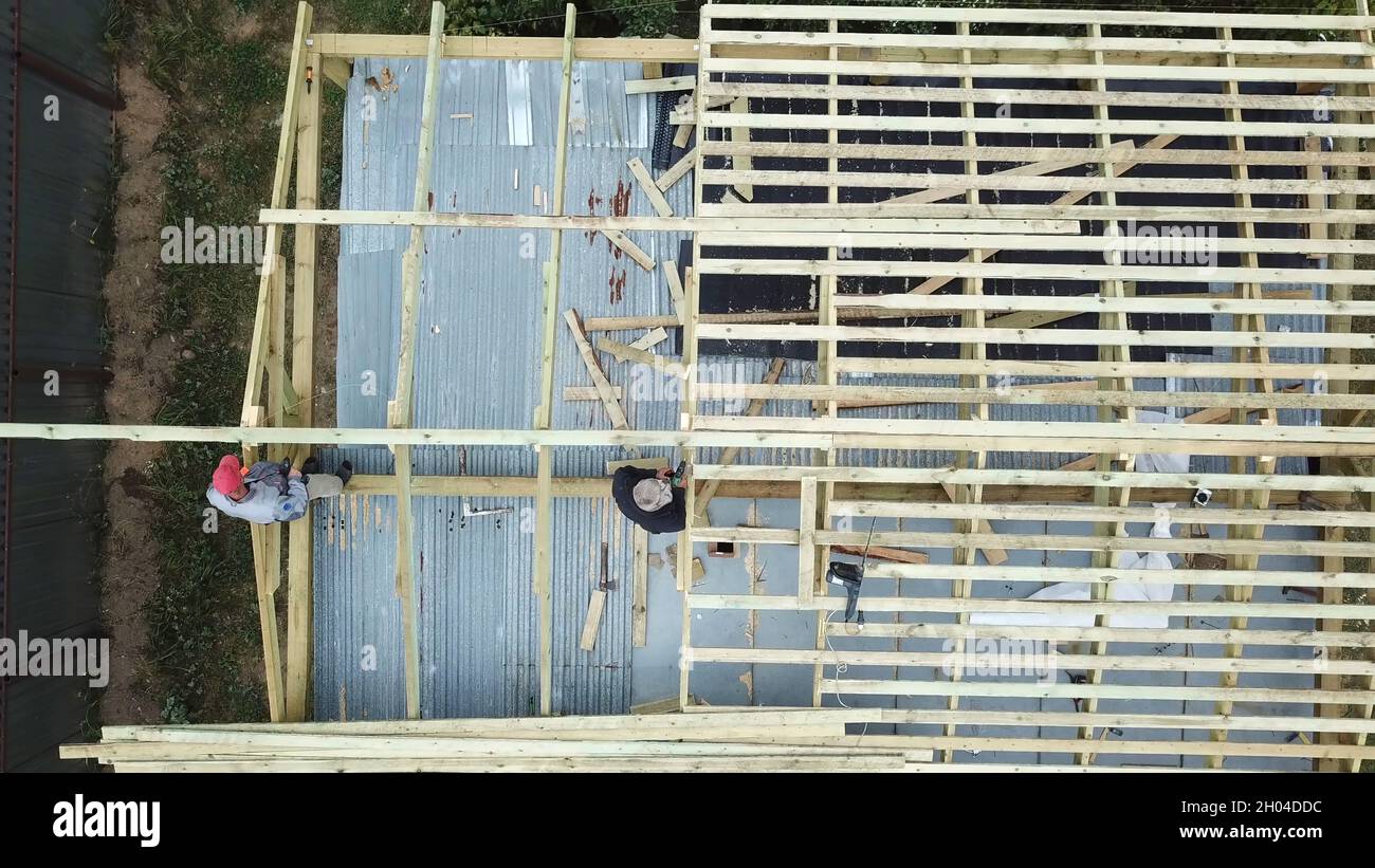 Aerial view of two senior men building a wooden frame house in the ...