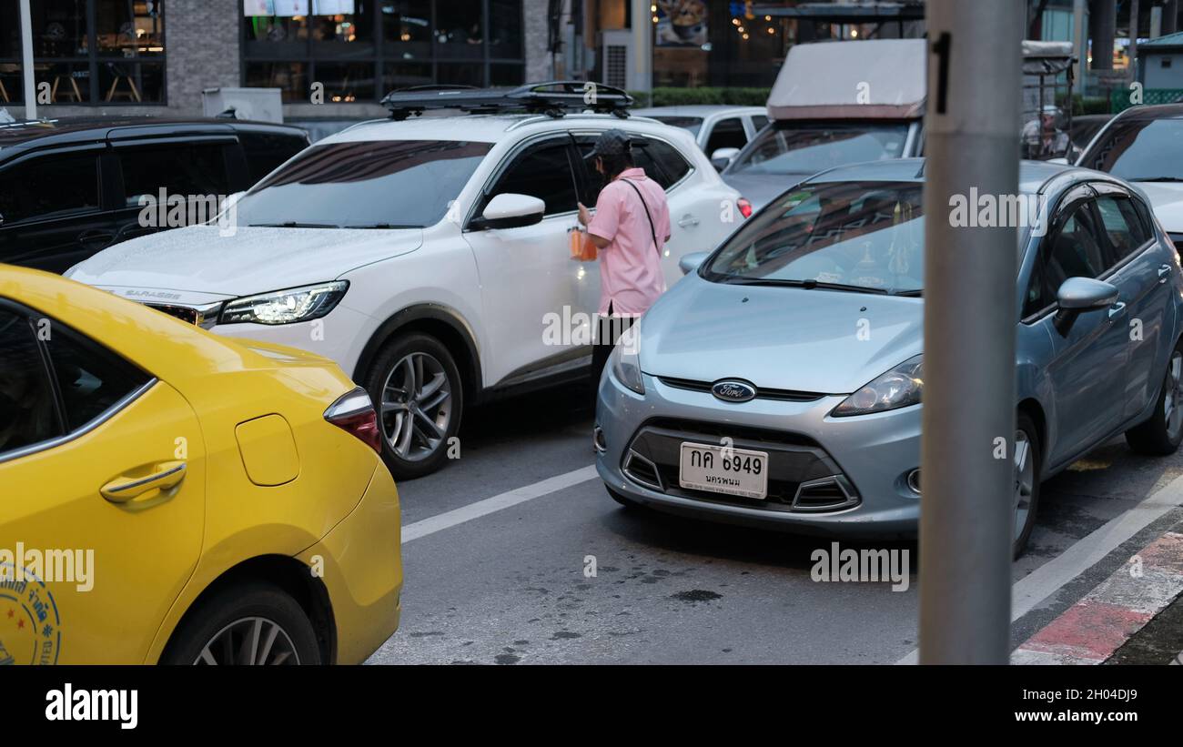 Lady selling good luck charms at intersection in Bangkok Thailand Stock ...