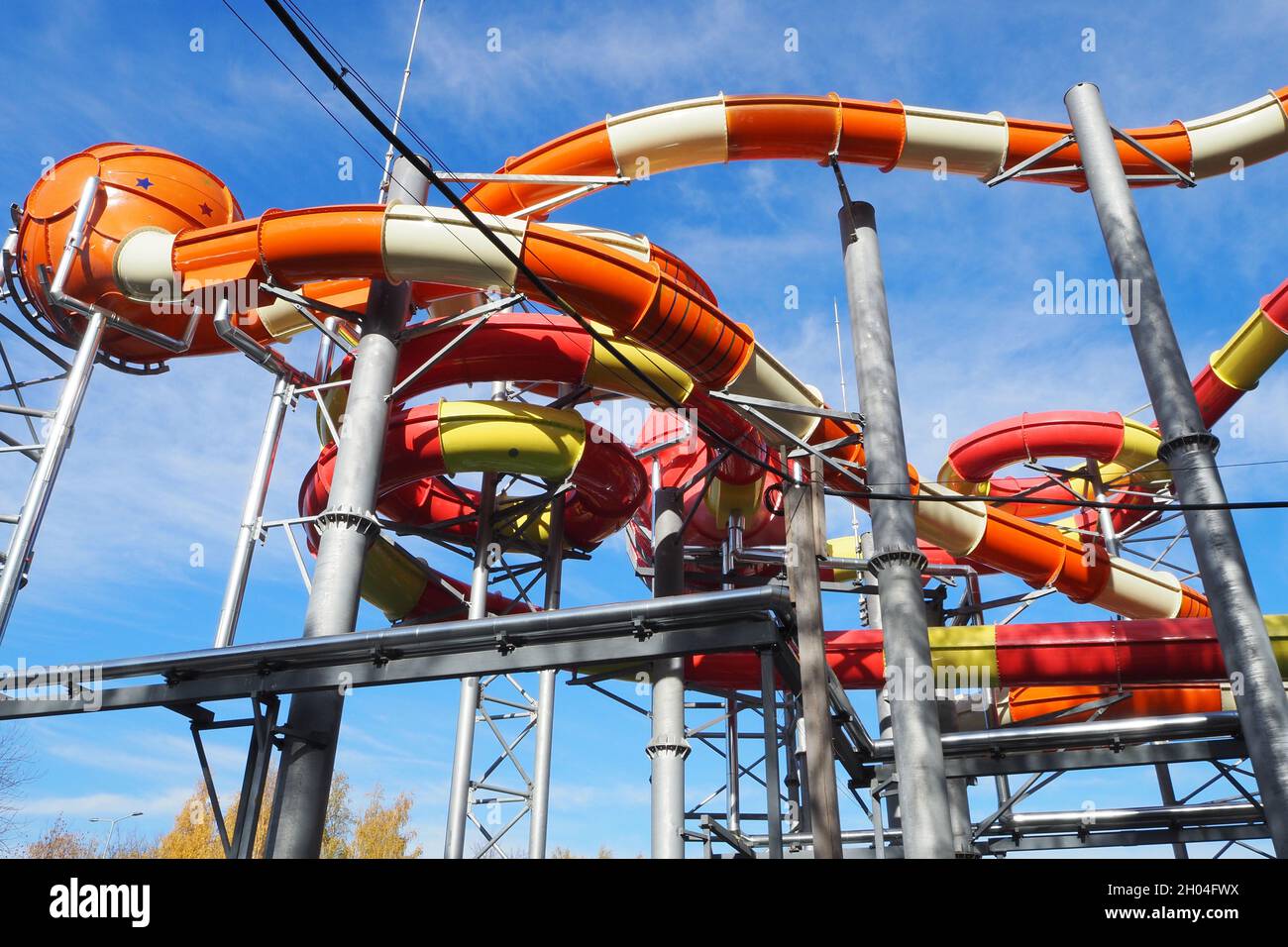 Bright colored water slides in the water park against the blue sky ...