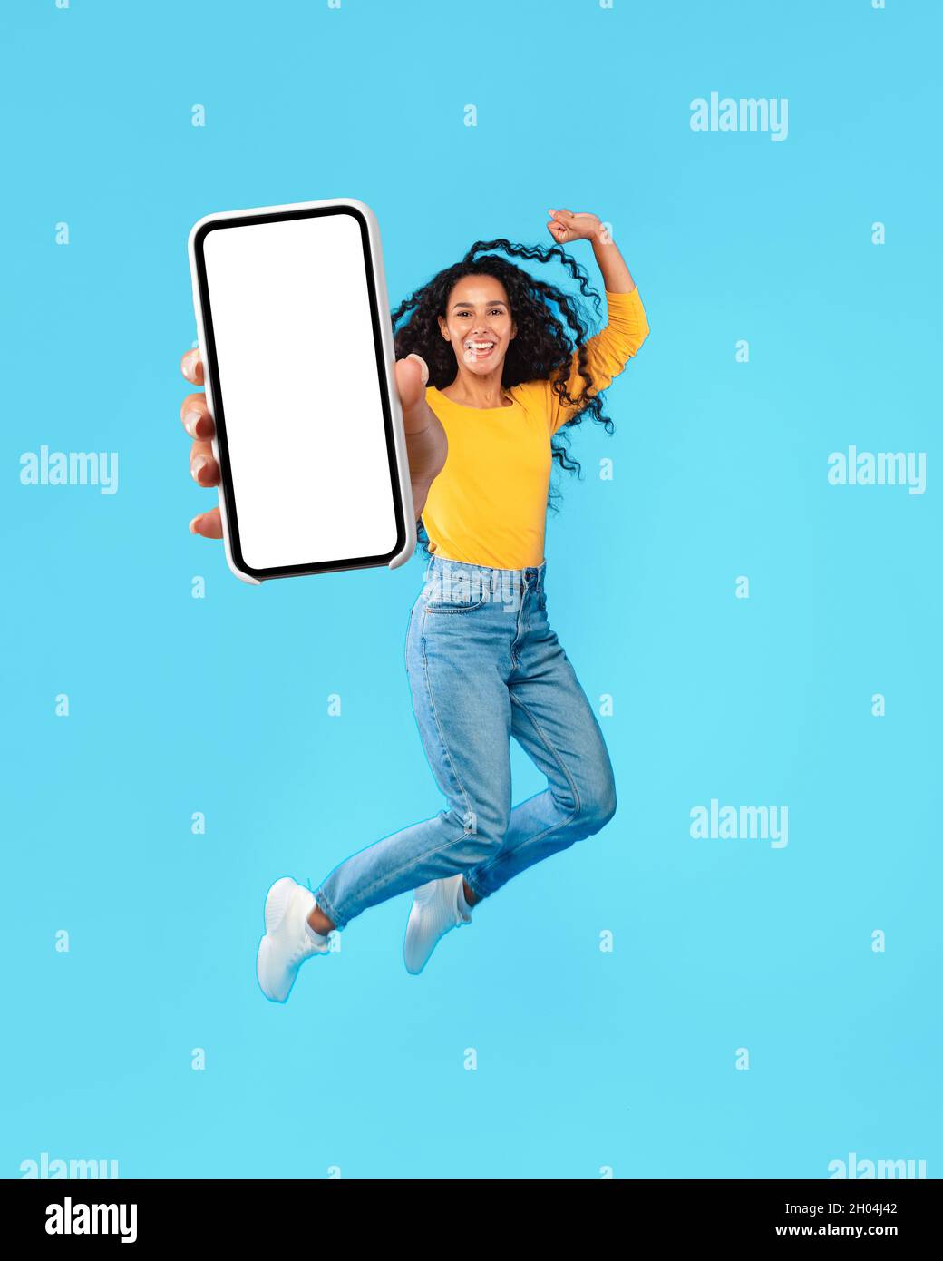 Happy Arab Female Jumping Up Showing Big Blank Smartphone Screen ... Happy Arab Female Jumping Up Showing Big Blank Smartphone Screen ...