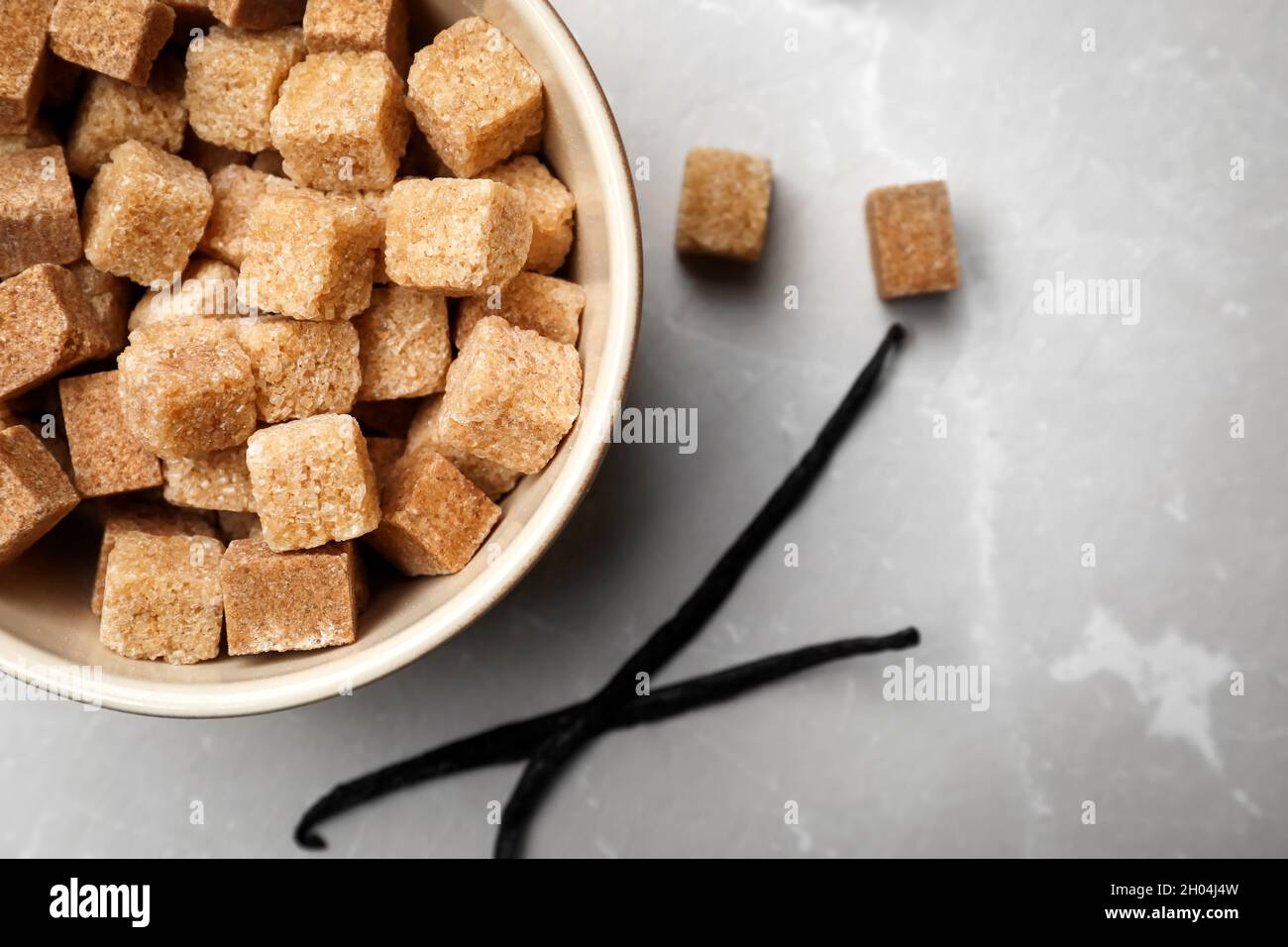 Bowl of aromatic vanilla lump sugar and sticks on grey background Stock ...