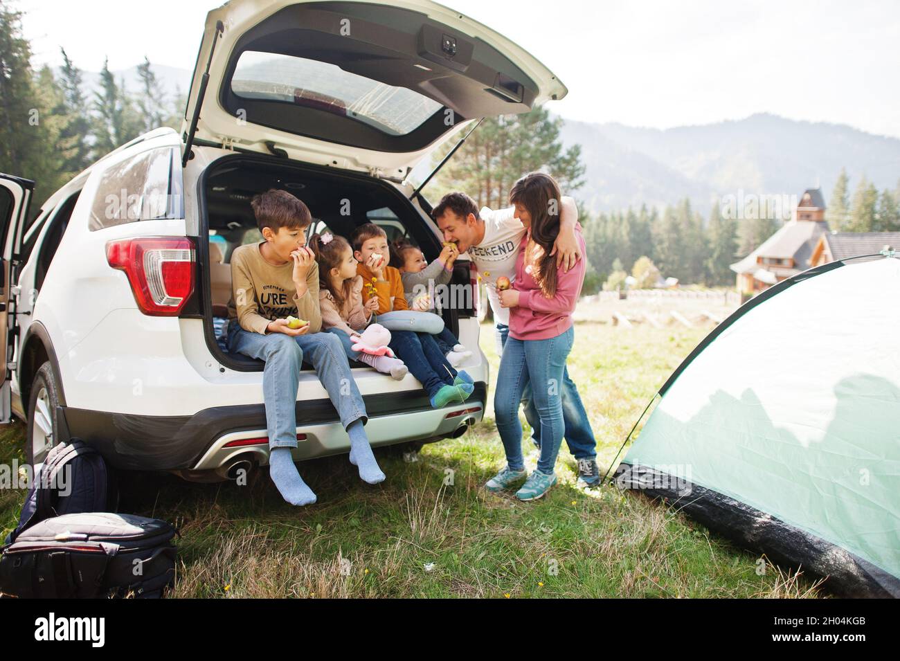 Large family of four kids. Children in trunk. Traveling by car in the ...