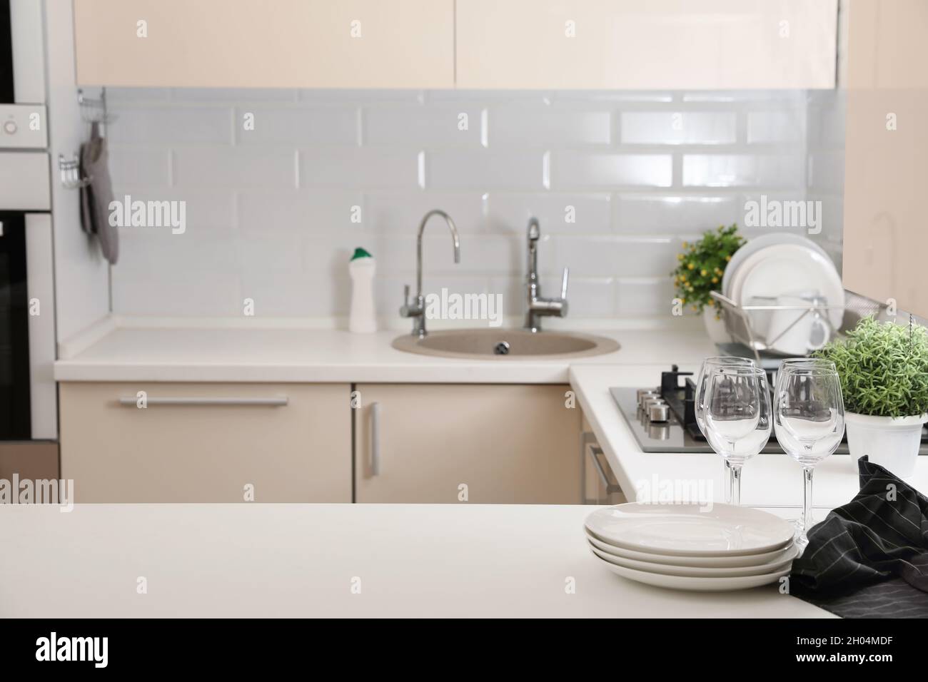 Stack of clean dishes and glasses on table in kitchen. Space for text ...