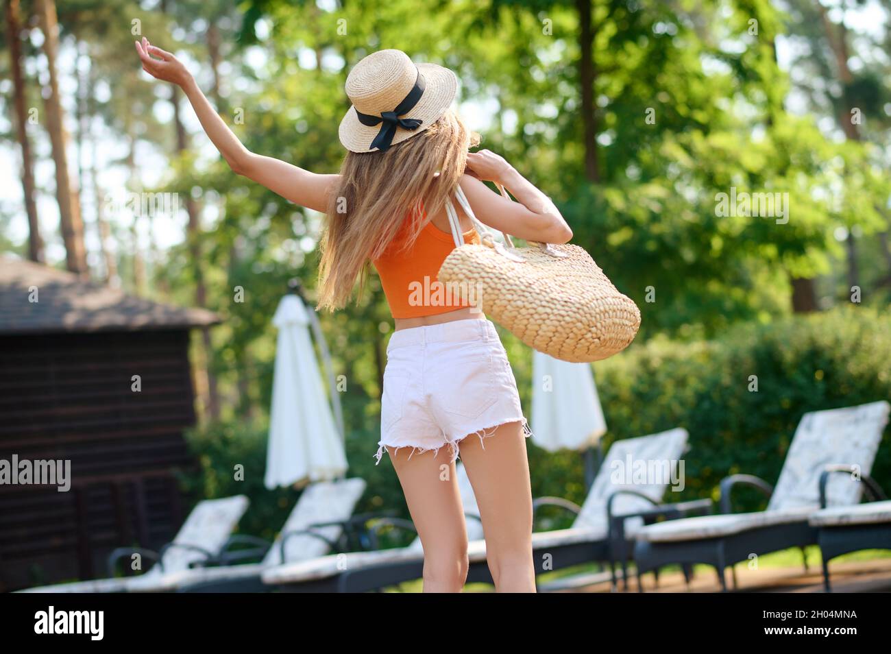 Pretty young woman walking in a park zone and looking happy Stock Photo ...