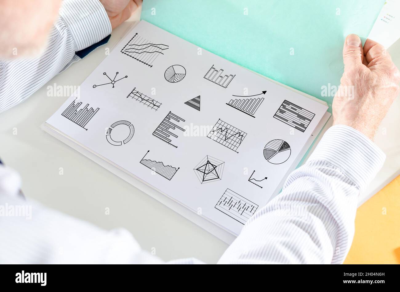 Man holding a file with graphical analysis concept Stock Photo - Alamy