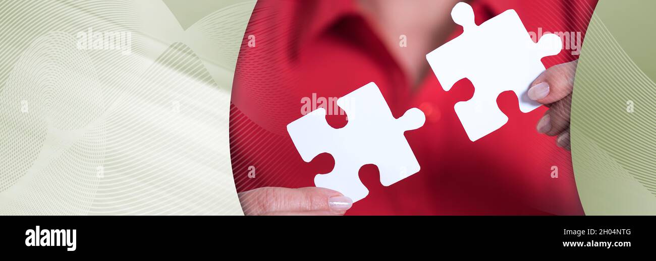 Hands joining two puzzle pieces, teamwork concept; panoramic banner ...