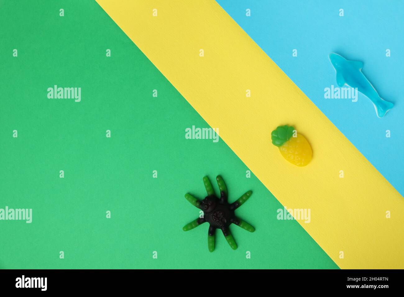 Tasty gummy candies on three tone background Stock Photo - Alamy