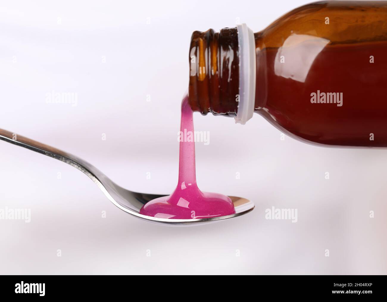 Pouring cough syrup into spoon on white background, closeup Stock Photo ...
